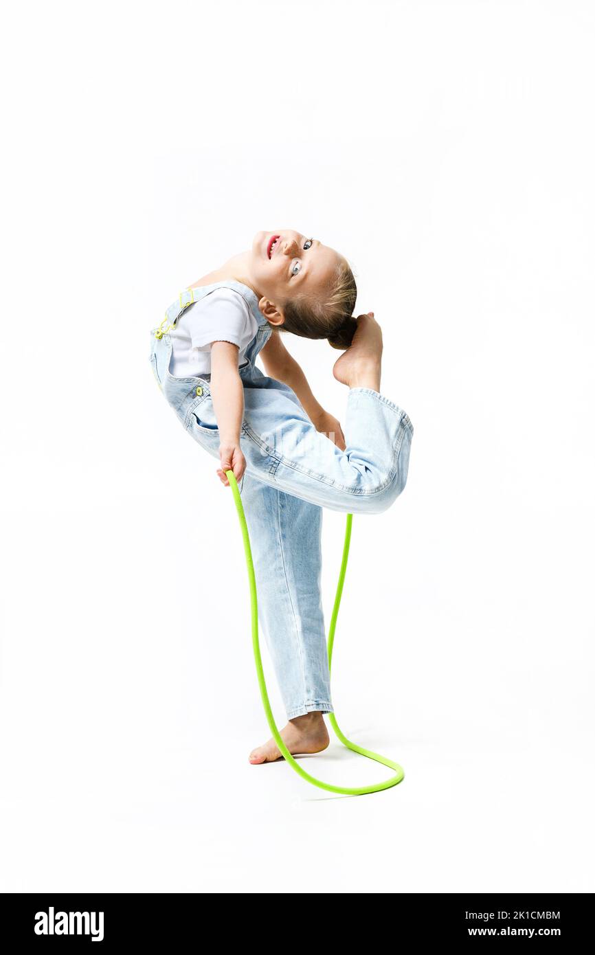 Flexible little gymnast dancer acrobat girl stretching body, put feet ...