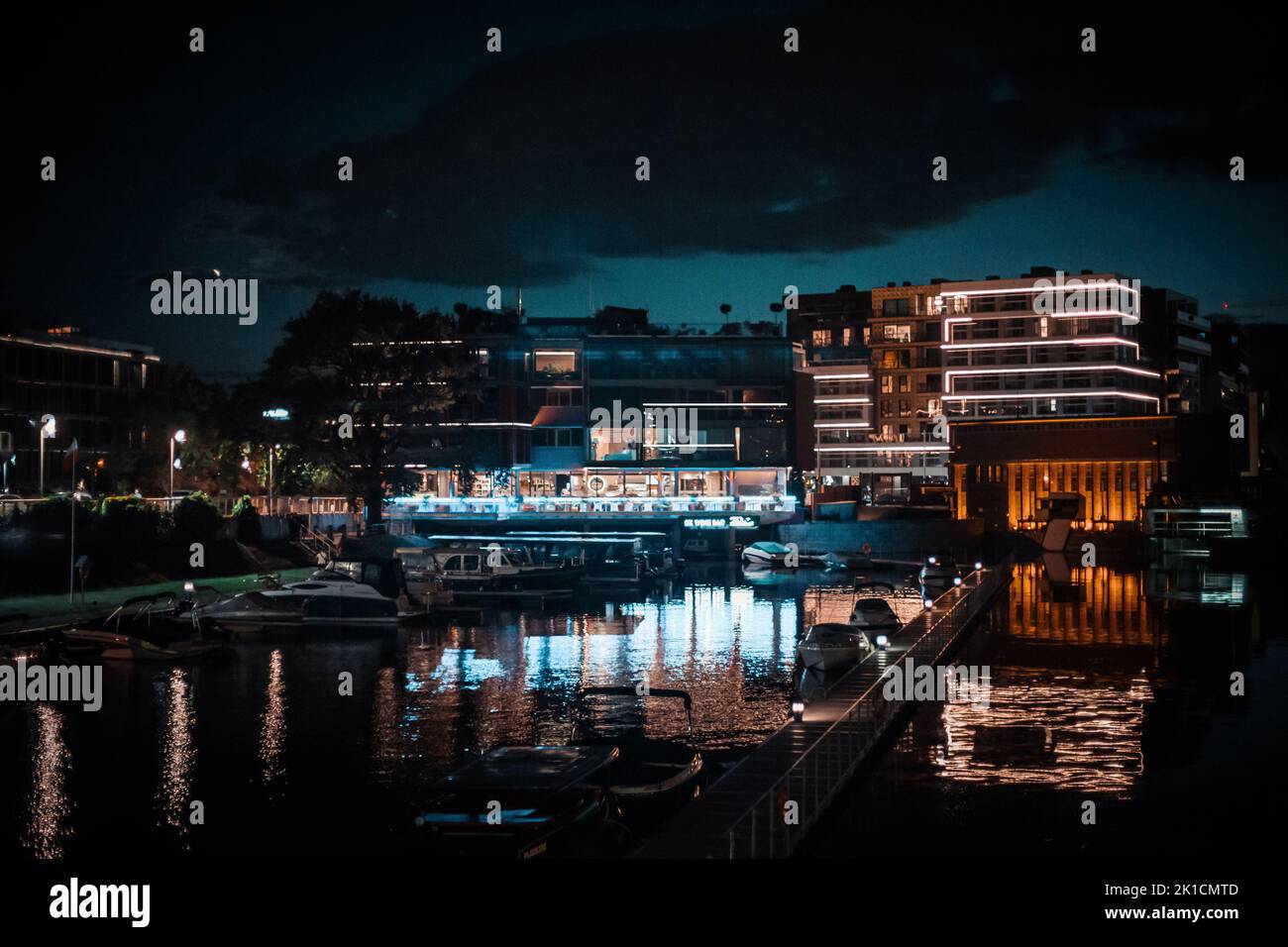 A night view of a harbor in Wroclaw, Poland with buildings and boats on ...