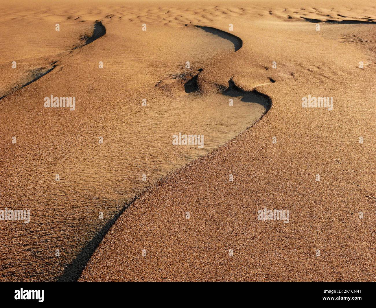 The aerial view of sand dunes creating lines and shapes under the ...