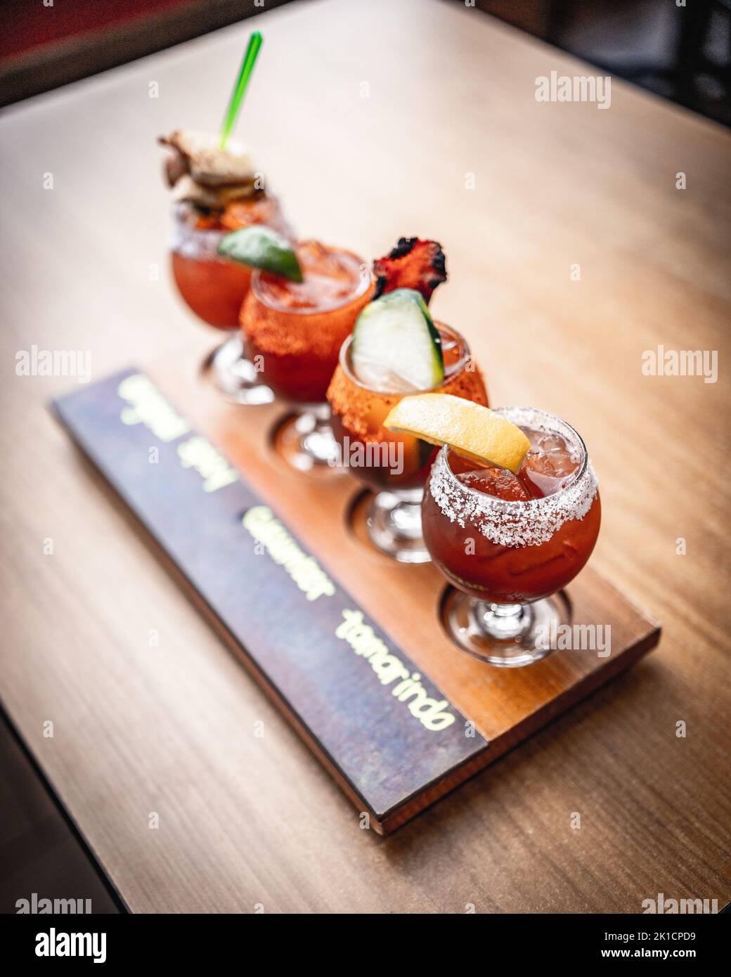 A closeup of set margarita cocktails with slice of lime and salty rim ...