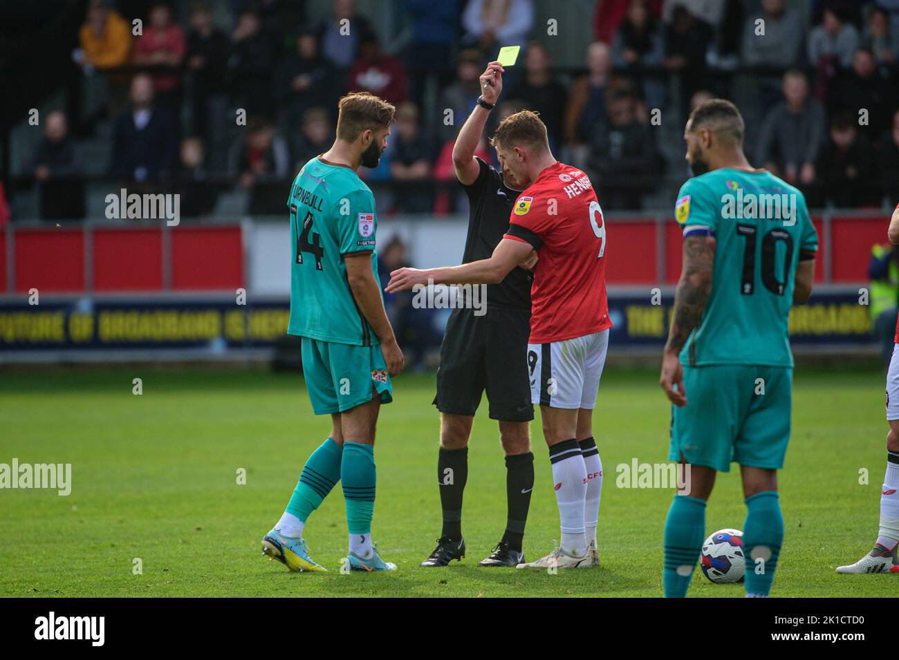 Referee David Rock shows Callum Hendry of Salford City a yellow card ...