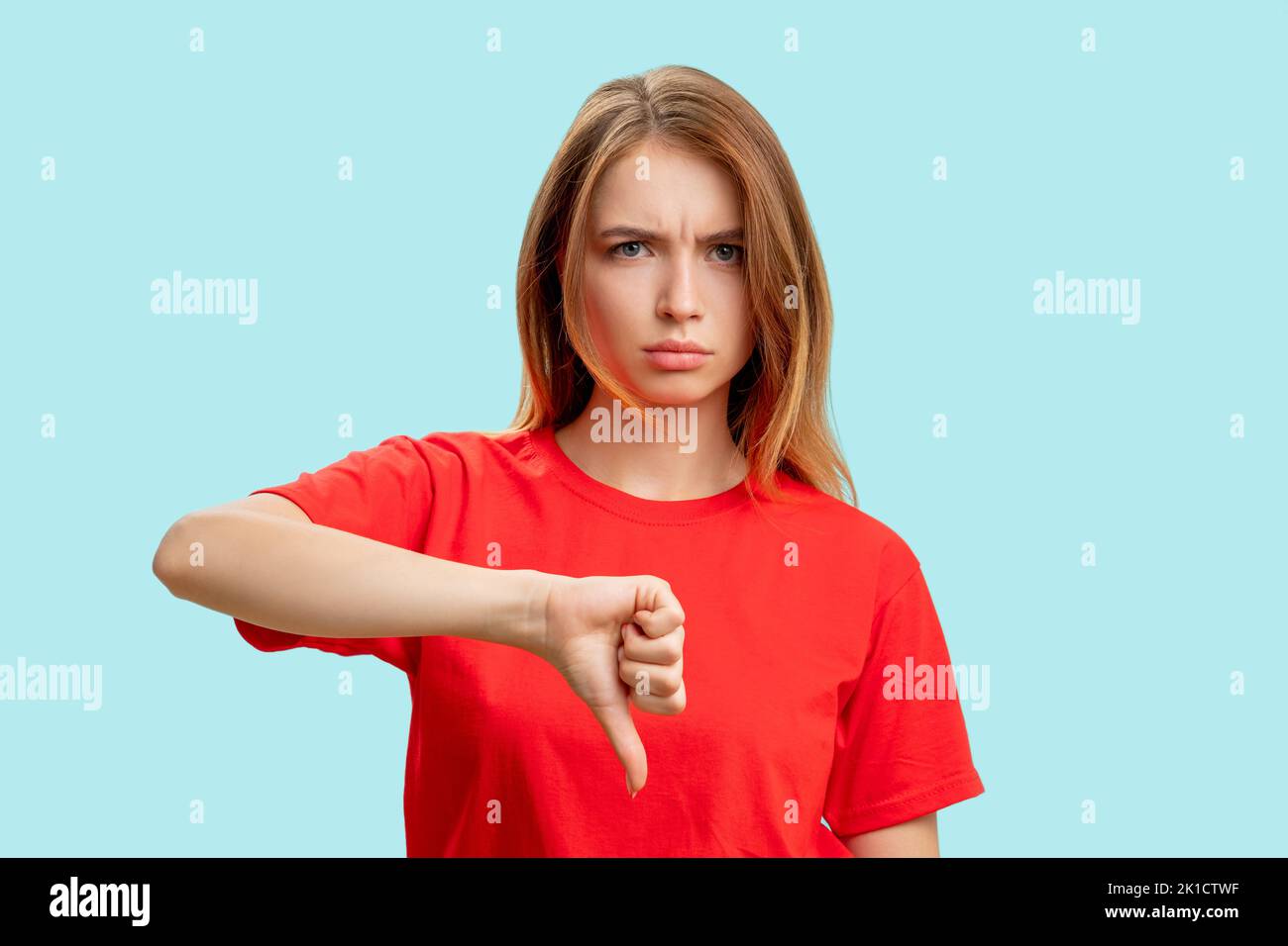 Dislike gesture. Refusal sign. Portrait of unhappy woman in red t-shirt ...