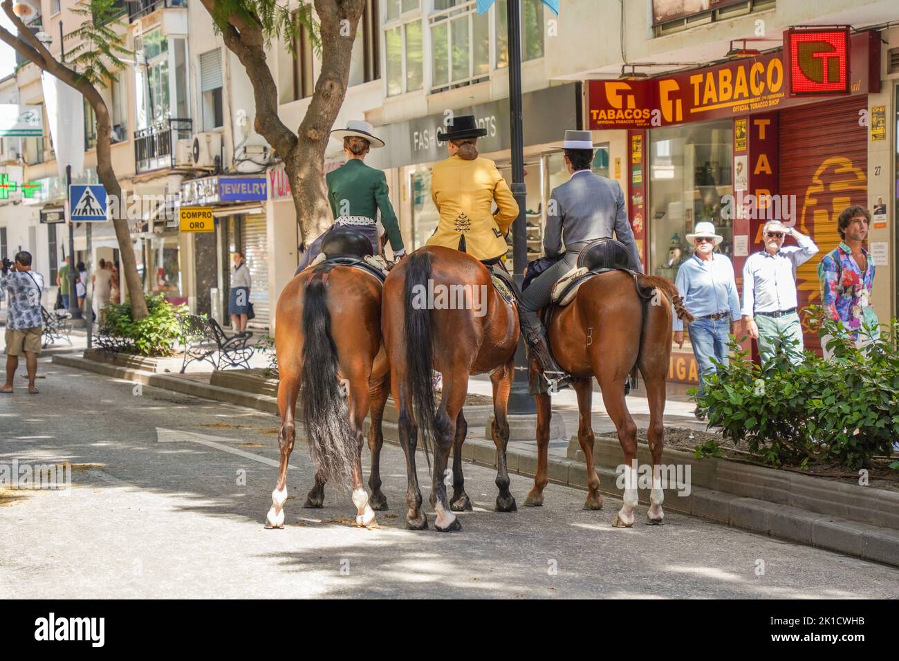 Men and women in traditional spanish costumes horseback riding during ...