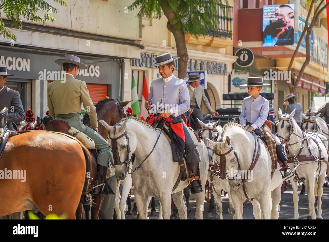 Men and women in traditional spanish costumes horseback riding during ...