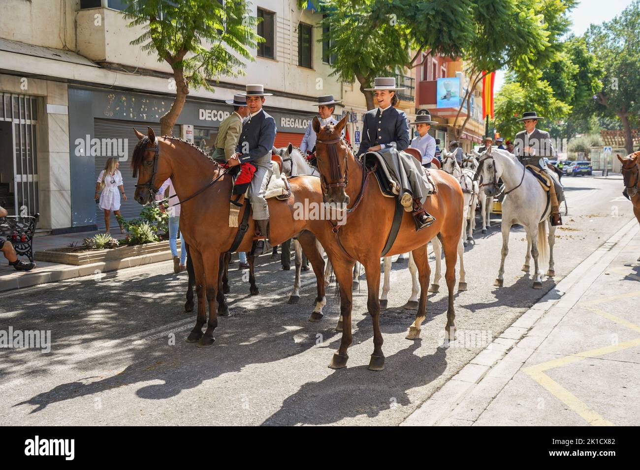 Men and women in traditional spanish costumes horseback riding during ...