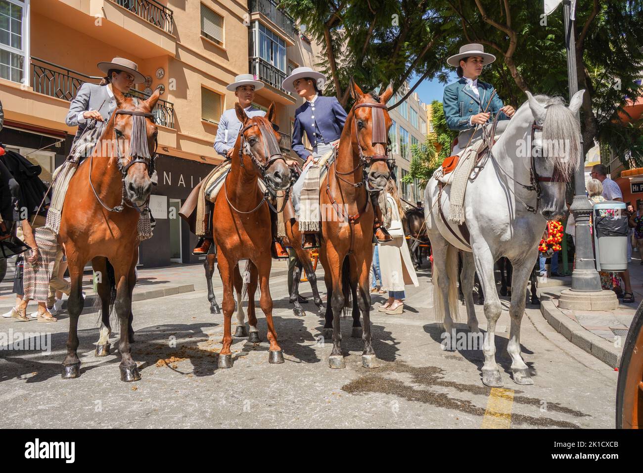 Men and women in traditional spanish costumes horseback riding during ...