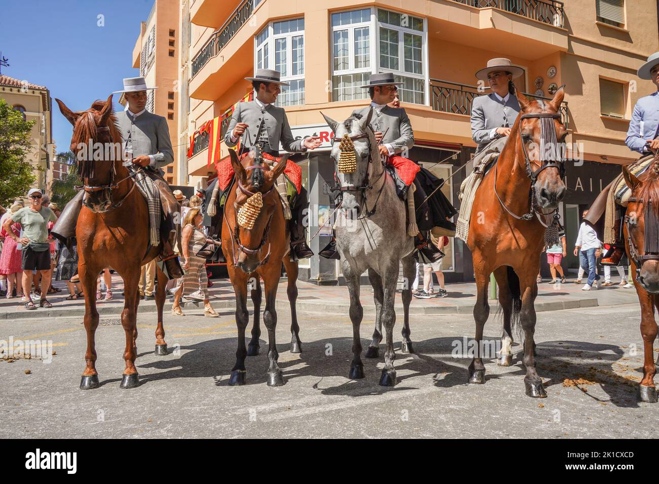 Men and women in traditional spanish costumes horseback riding during ...