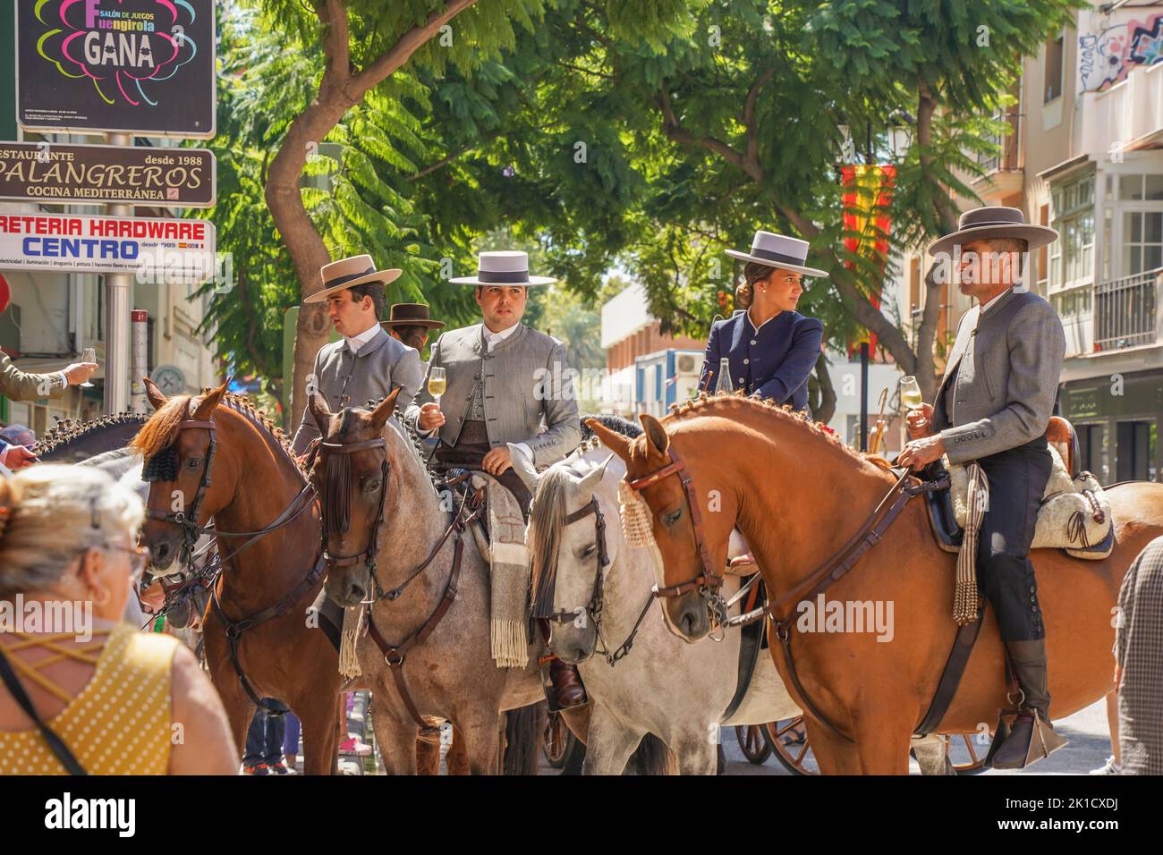Men and women in traditional spanish costumes horseback riding during ...