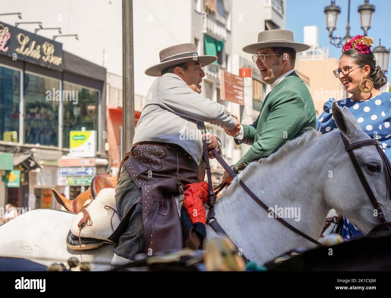 Men and women in traditional spanish costumes horseback riding during ...