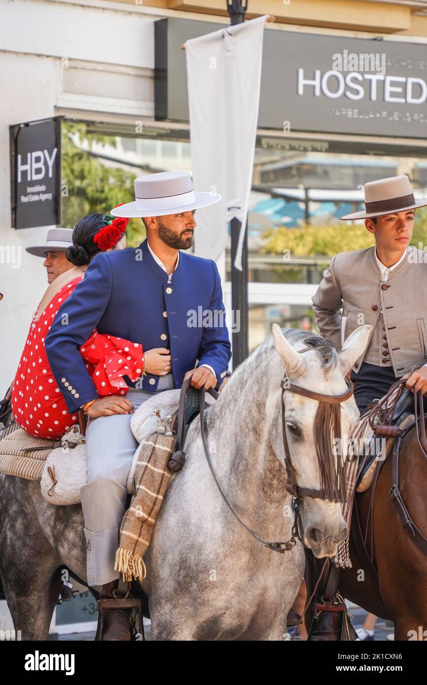 Man and woman in traditional spanish costumes horseback riding during ...