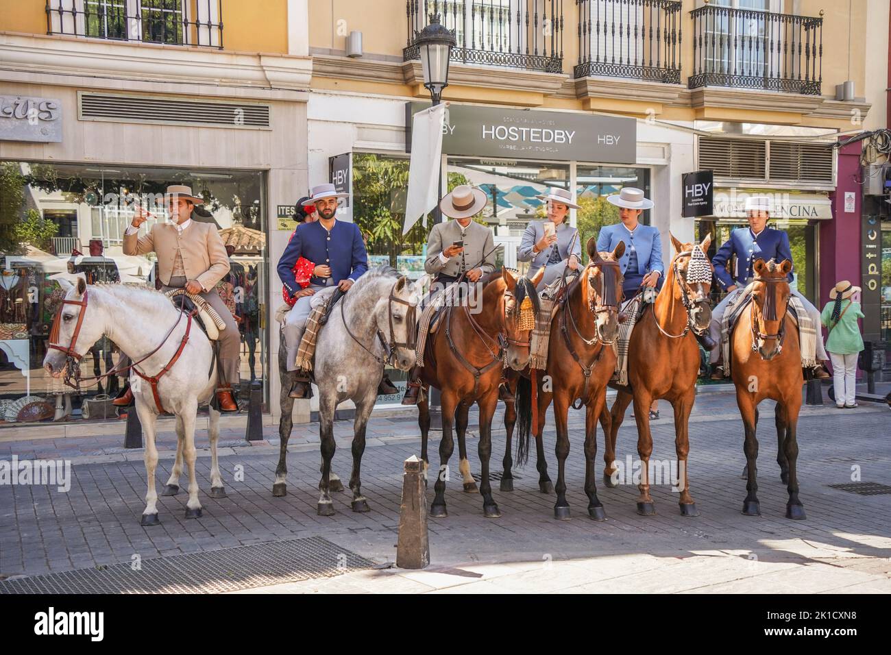 Men and women in traditional spanish costumes horseback riding during ...