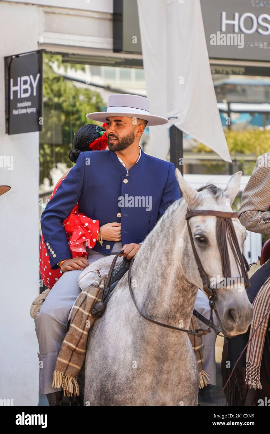 Man and woman in traditional spanish costumes horseback riding during ...