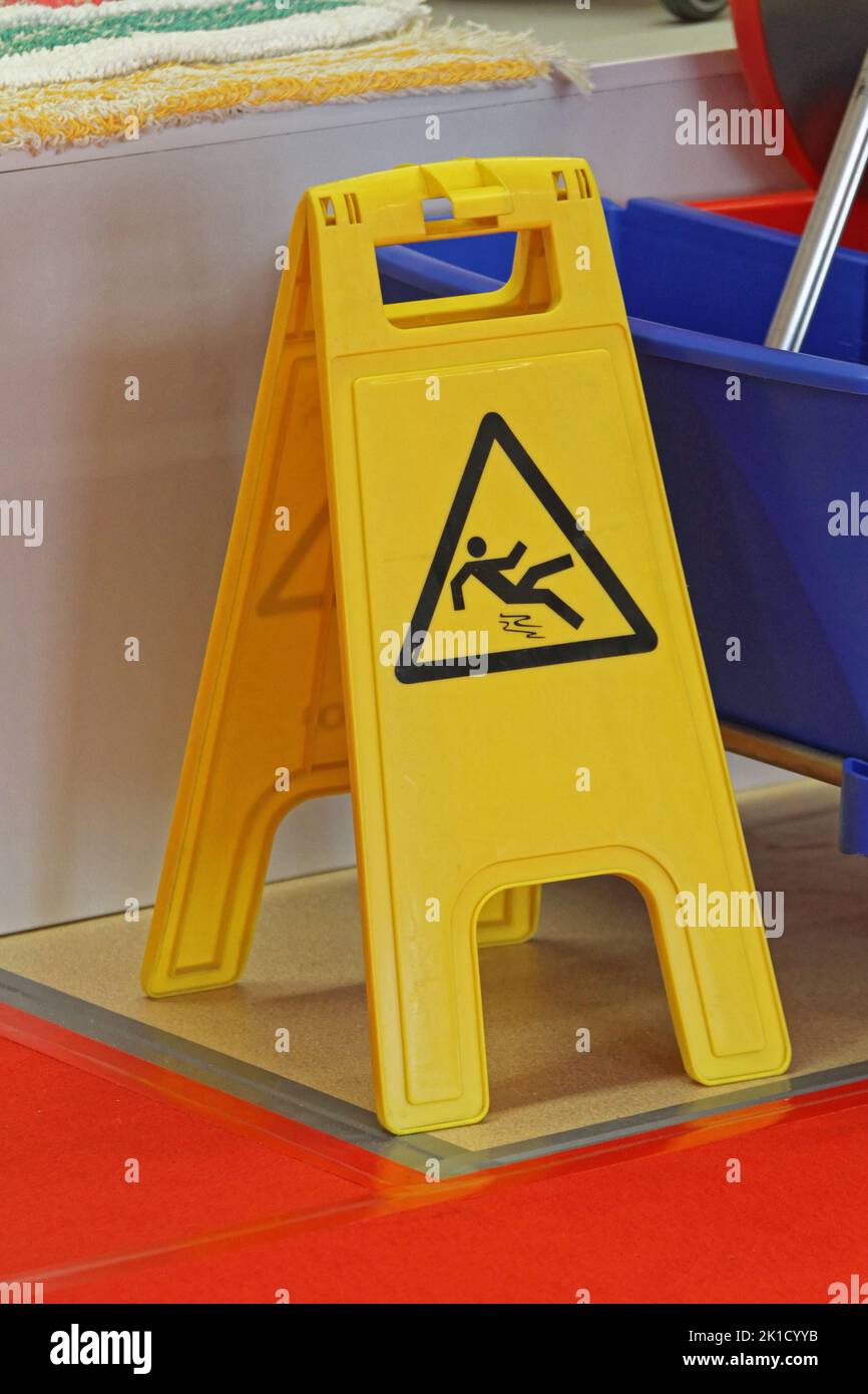 Bright yellow caution wet floor warning sign Stock Photo - Alamy