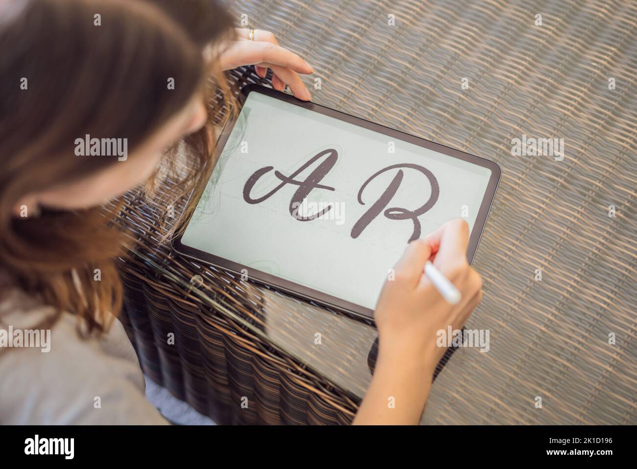 Calligrapher Young Woman writes phrase on digital tablet. Inscribing ...