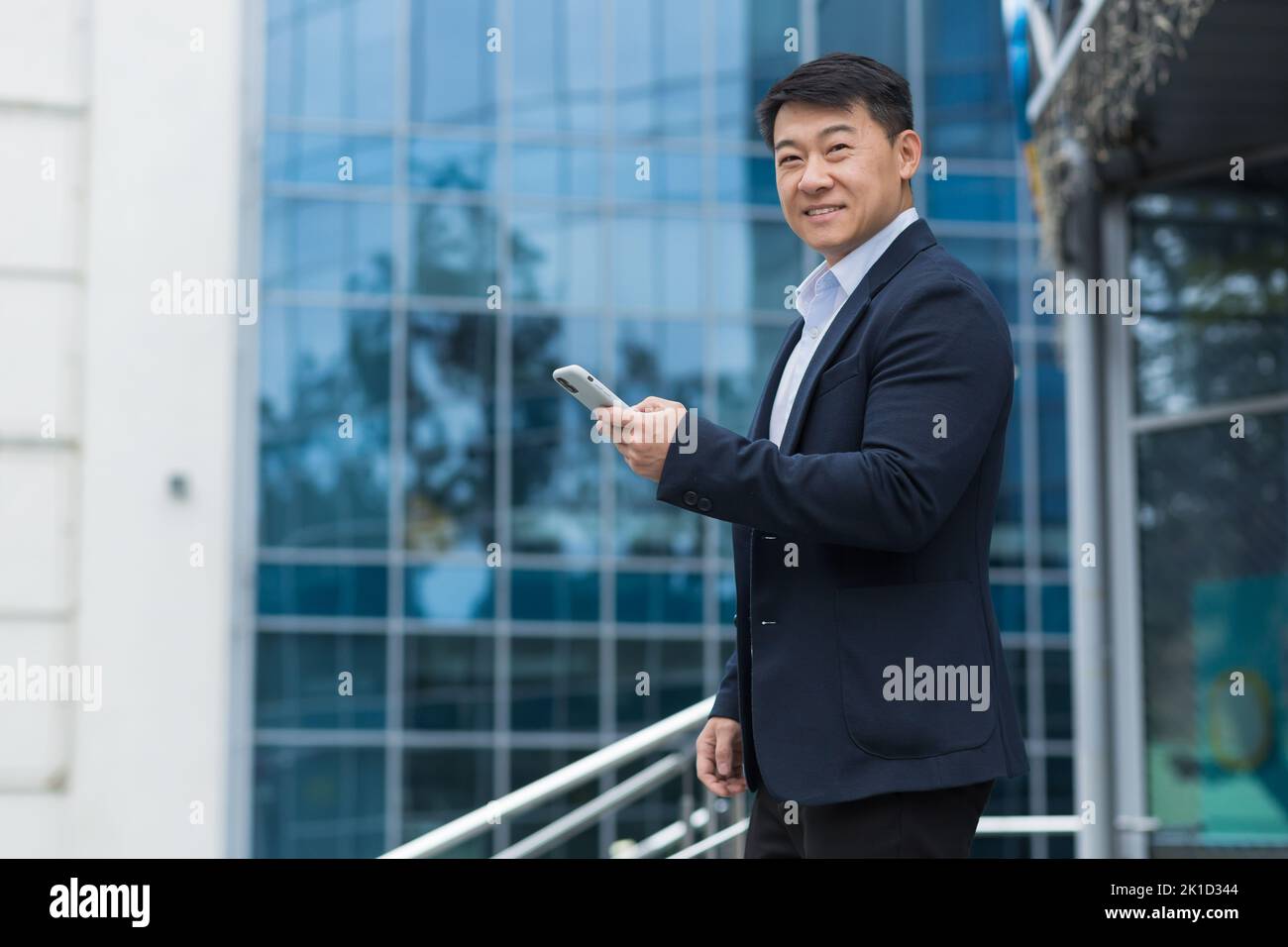 Portrait of an Asian businessman outside an office building, a man in a ...