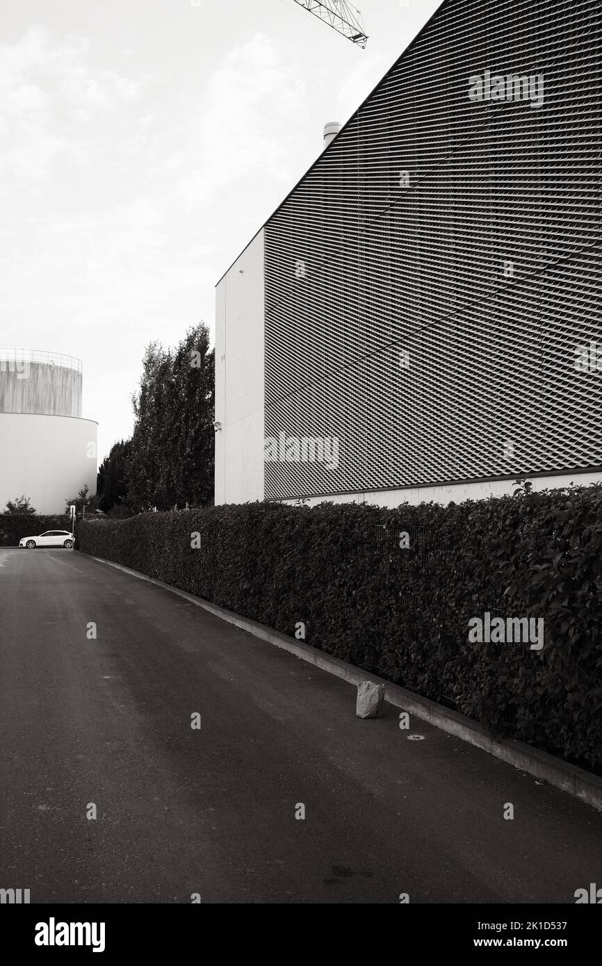 A vertical grayscale of a street with a building with a patterned ...
