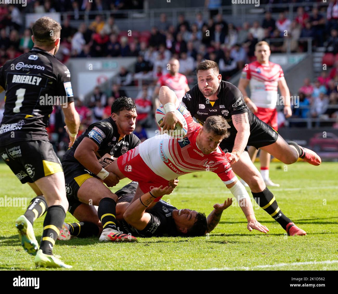 Louie McCarthy-Scarsbrook #15 of St Helens is tackled by Elijah Taylor ...