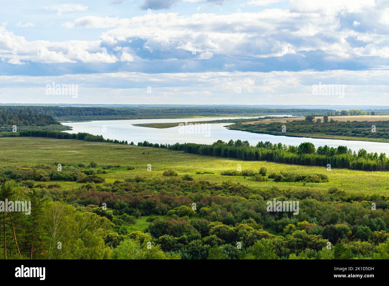 Long narrow shallow river on horizon with cloudy skies in valley ...