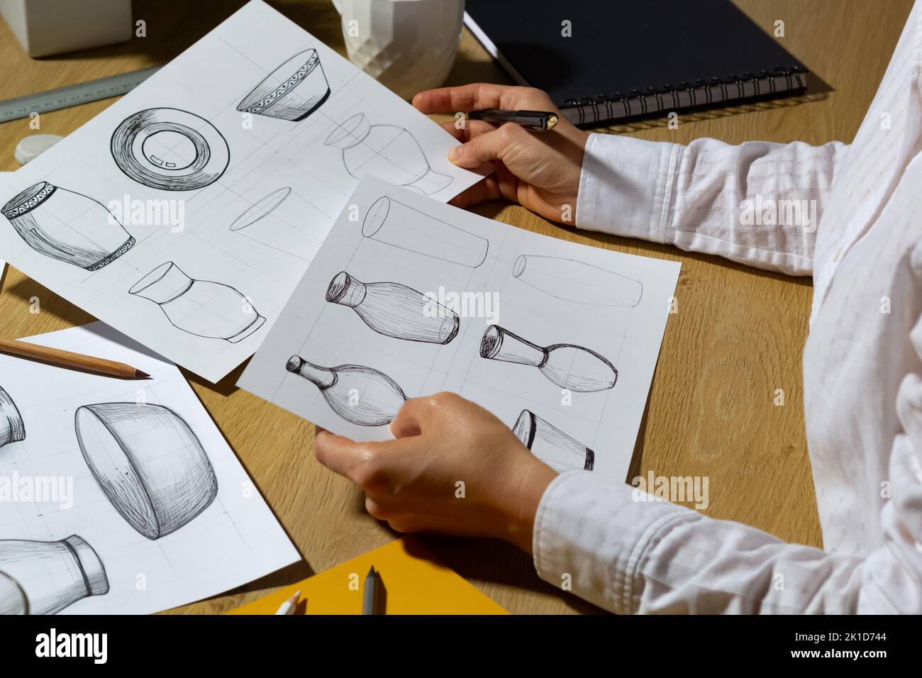 The designer draws sketches of kitchen utensils on paper. The artist ...