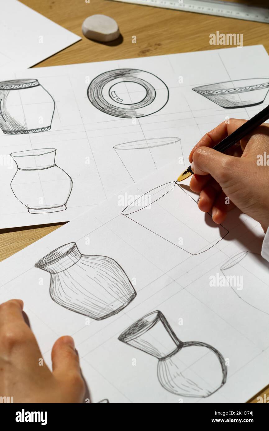 The designer draws sketches of kitchen utensils on paper. The artist ...