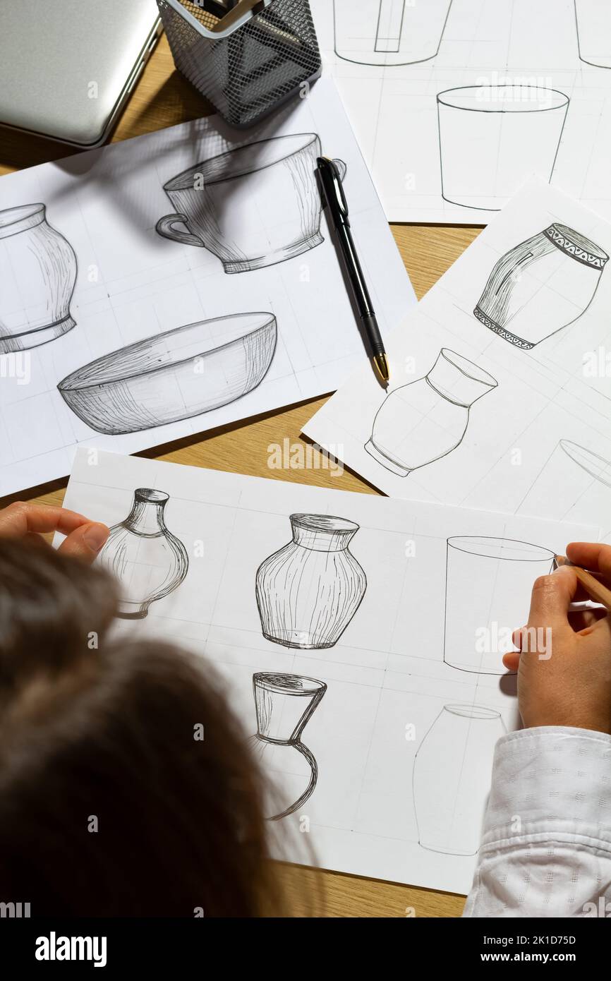 The designer draws sketches of kitchen utensils on paper. The artist ...