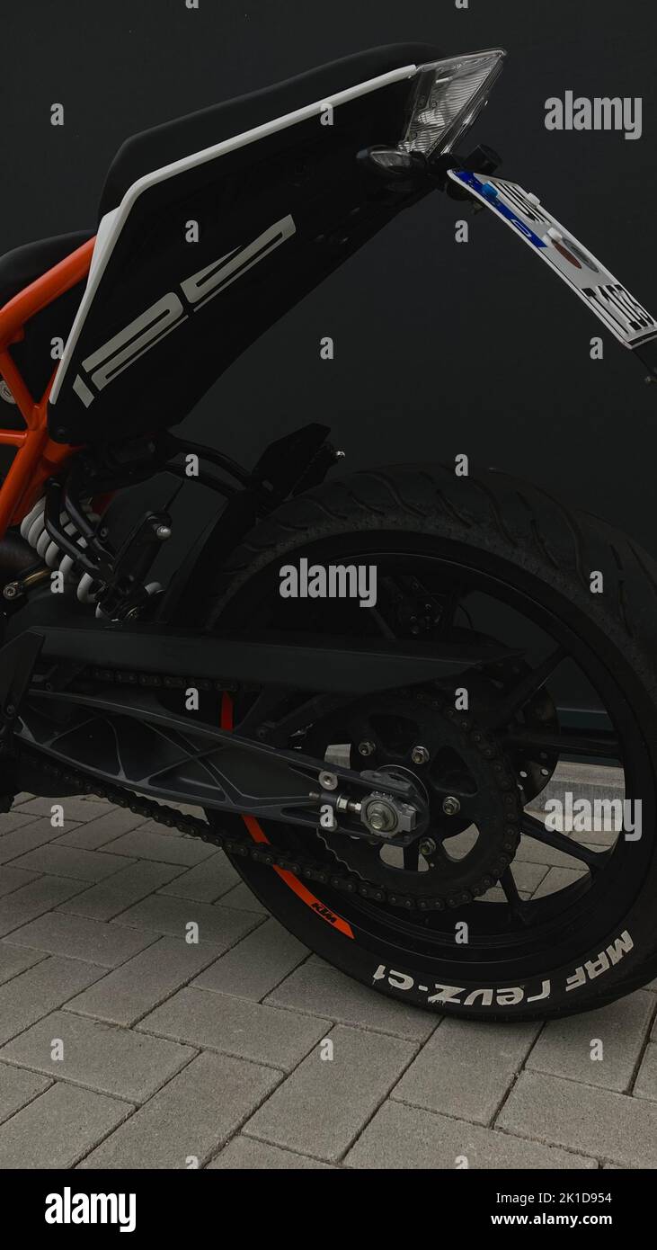 A vertical closeup side view of KTM Duke 125 motorcycle in dark themes ...