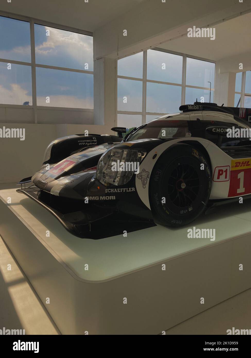 A vertical closeup shot of a Porsche 919 Hybrid Le Mans car in a museum ...