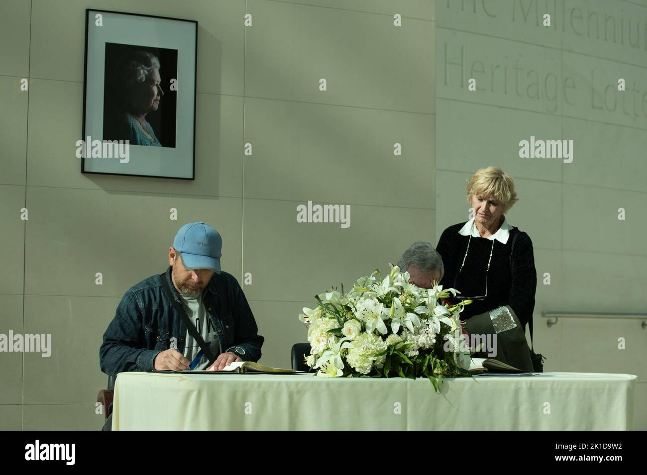 Hundreds of people write their condolence messages in a book at the ...