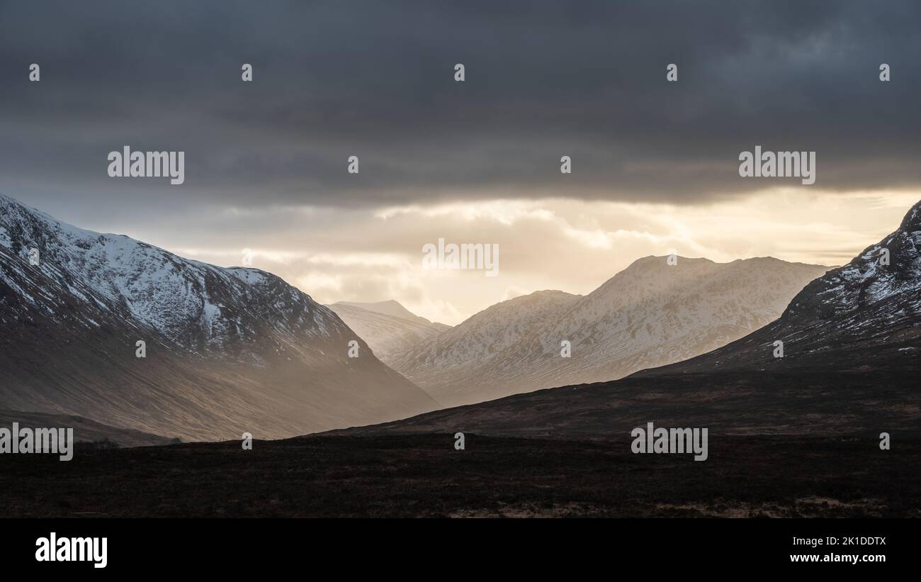 Stunning dramatic Winter sunset sunbeams over landscape of Lost Valley ...