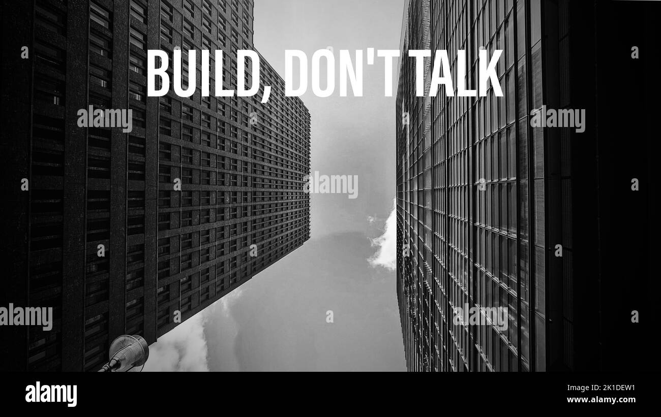 A low angle grayscale shot of two urban skyscrapers under gray sky with ...