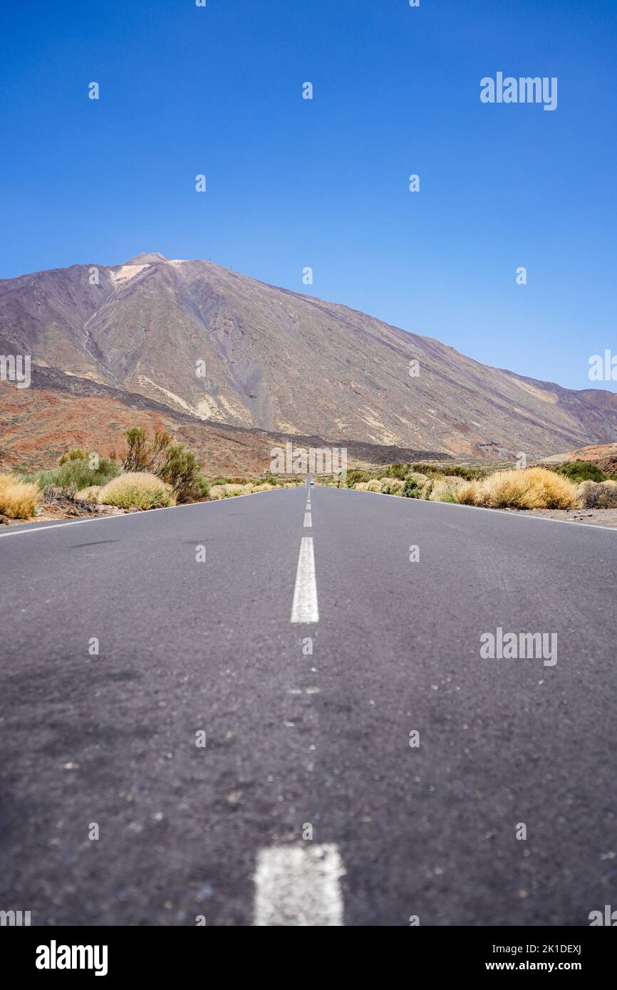 A vertical shot of a road between mountains during daytime Stock Photo ...