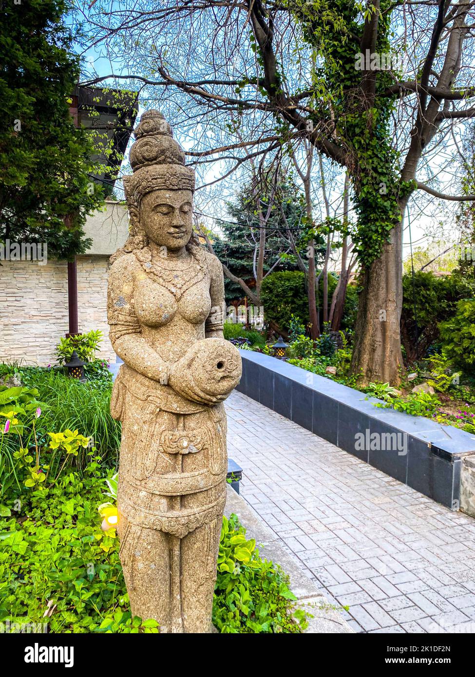 A Moai sculpture in a park under a clear blue sky Stock Photo - Alamy