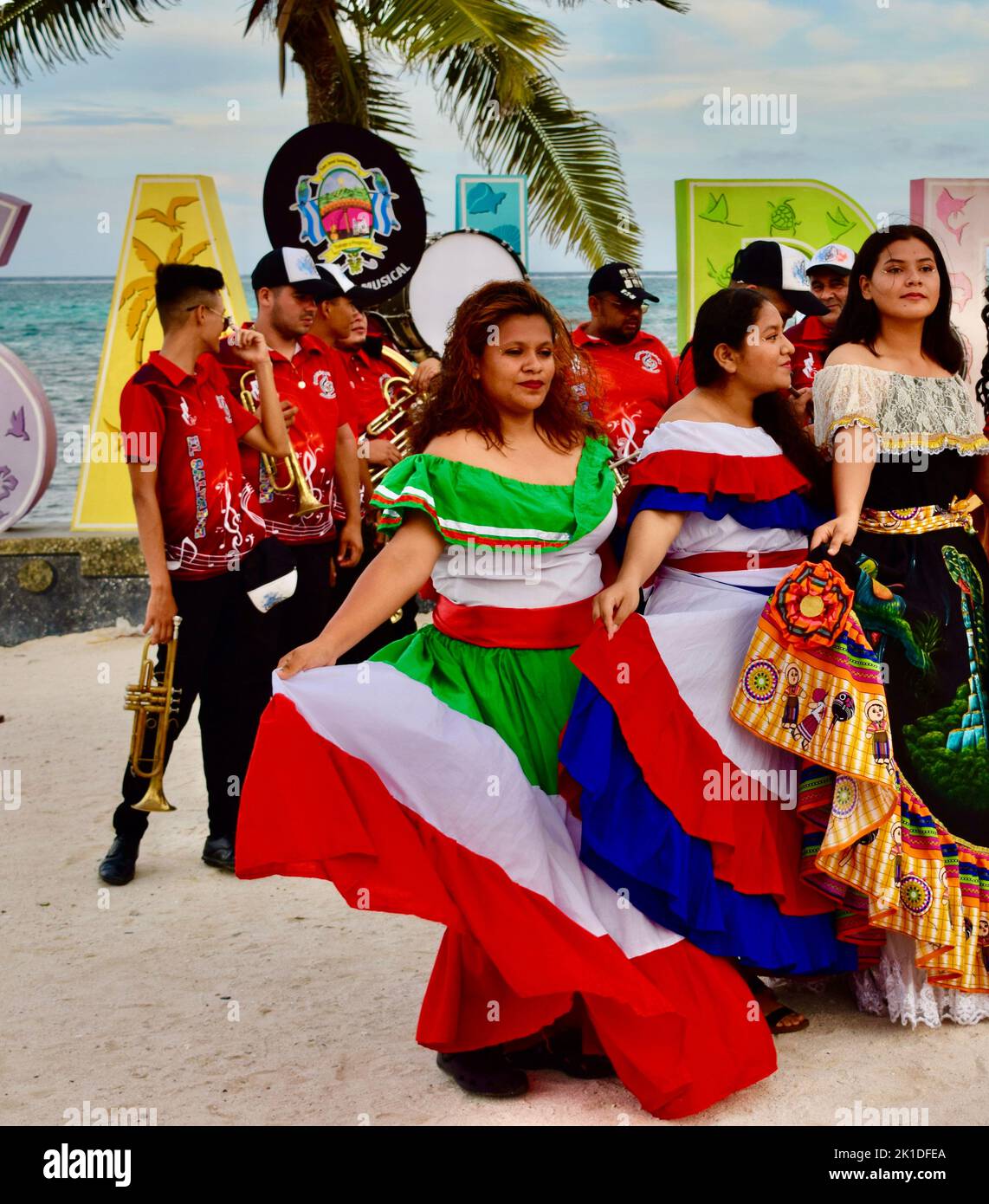 3 ladies in traditional Latin American dresses, representing from left ...