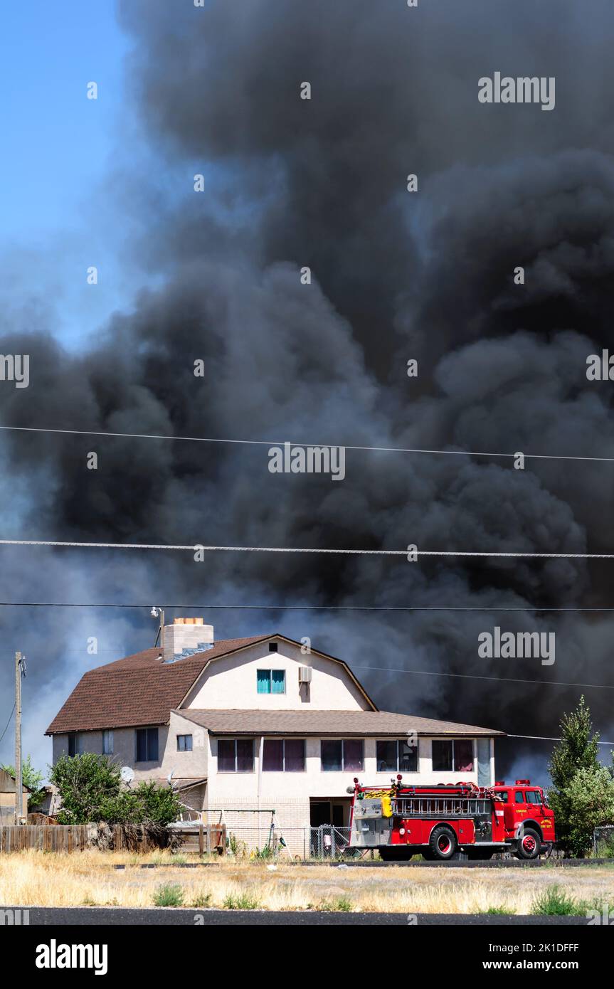 Firetruck at the scene of a house fire with huge clouds of billowing ...