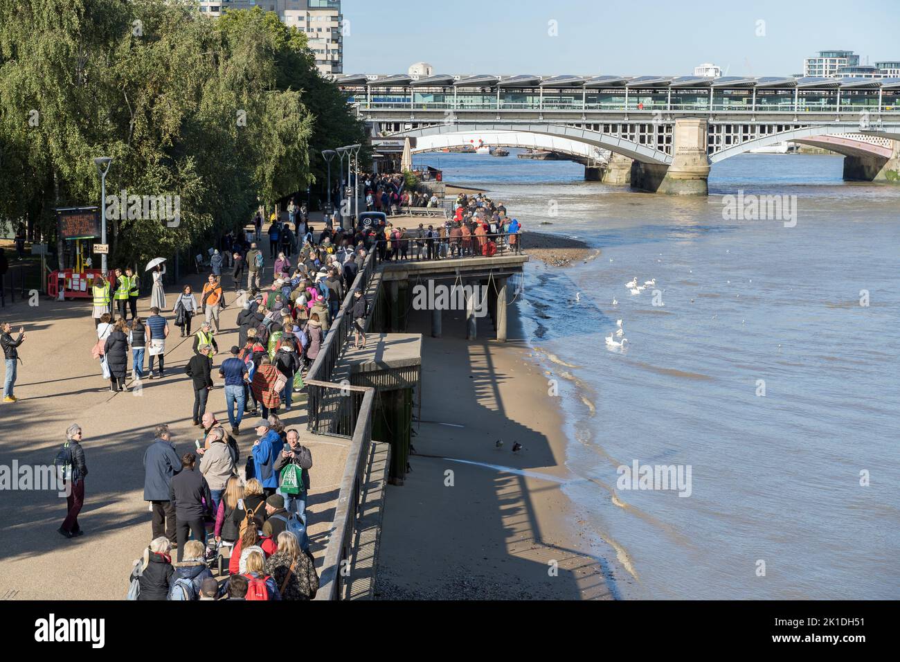 Queue along the banks of the River Thames, people waiting to pay their ...