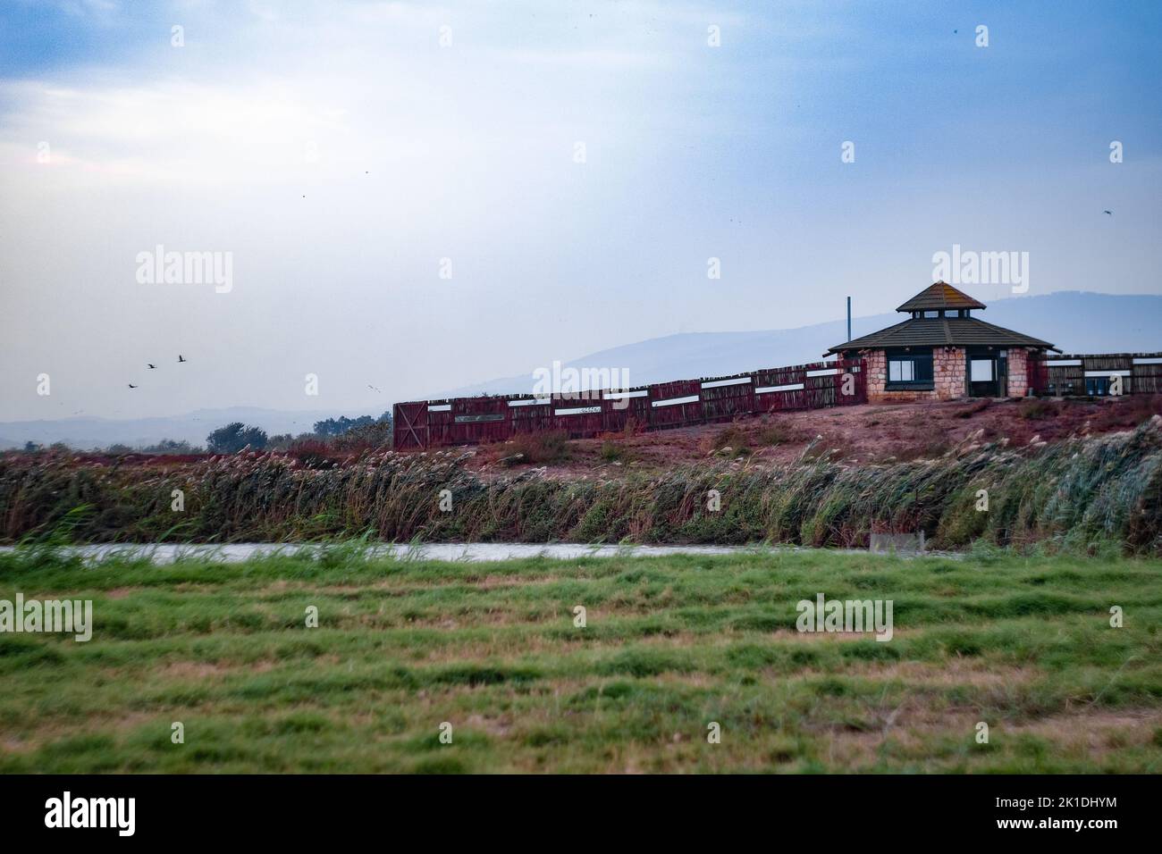 A beautiful building near a water stream and a green field under a ...