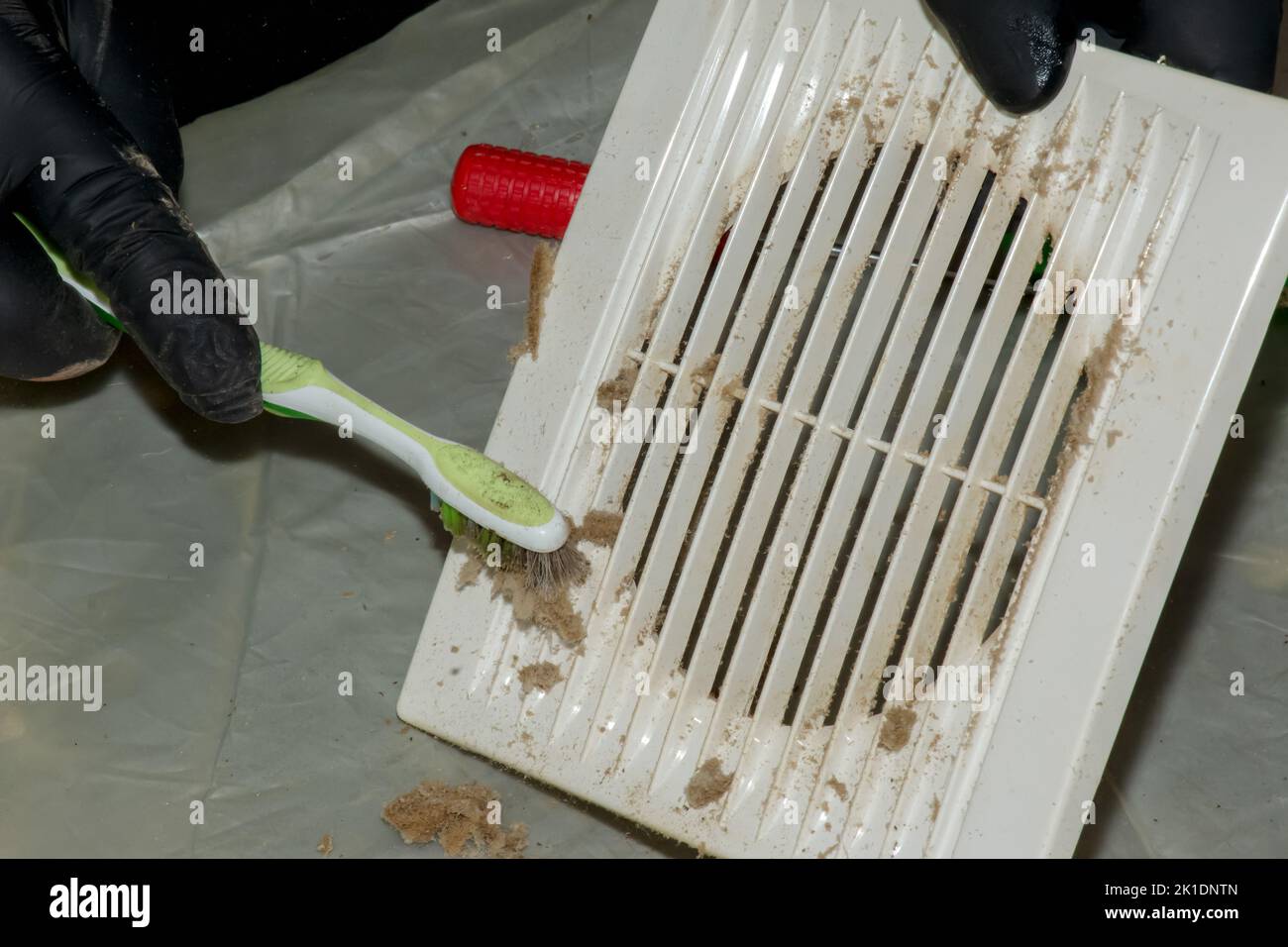 Cleaning a very dirty kitchen exhaust fan from dirt with a brush. A man ...