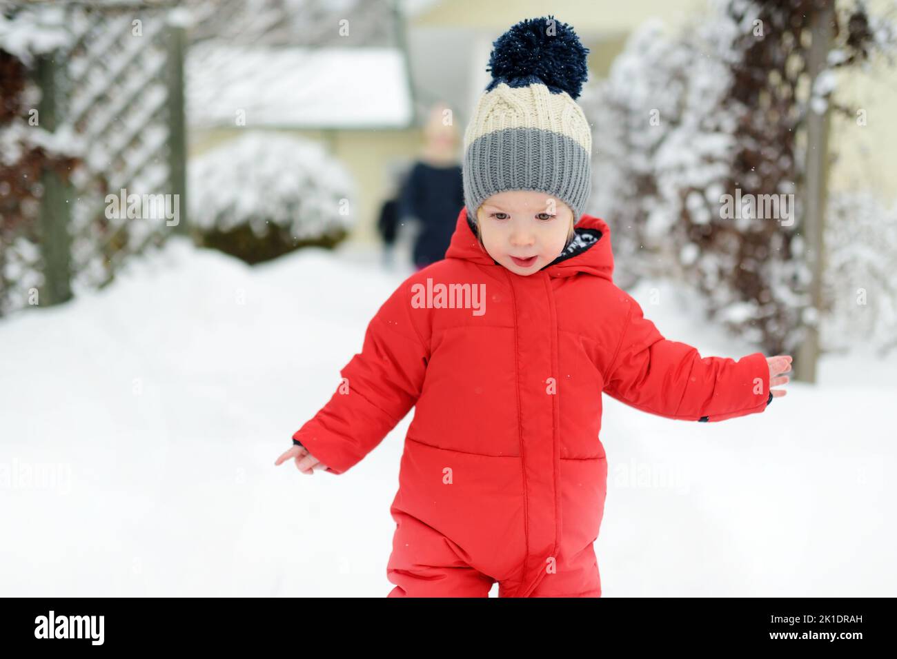 Adorable toddler boy having fun in snow covered park on chilly winter ...