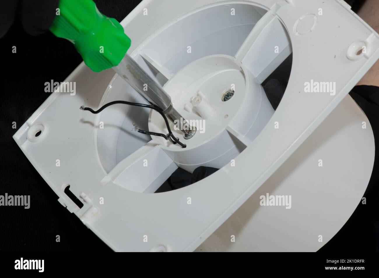 The process of assembling the kitchen exhaust fan after cleaning the ...