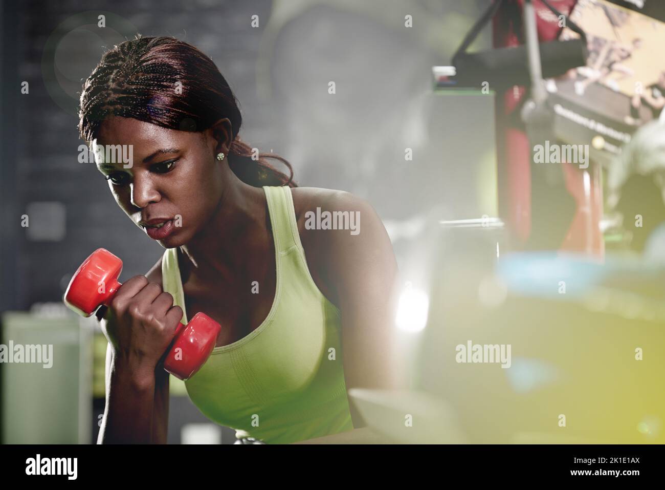 Consistent and persistent. a young woman lifting weights at the gym ...