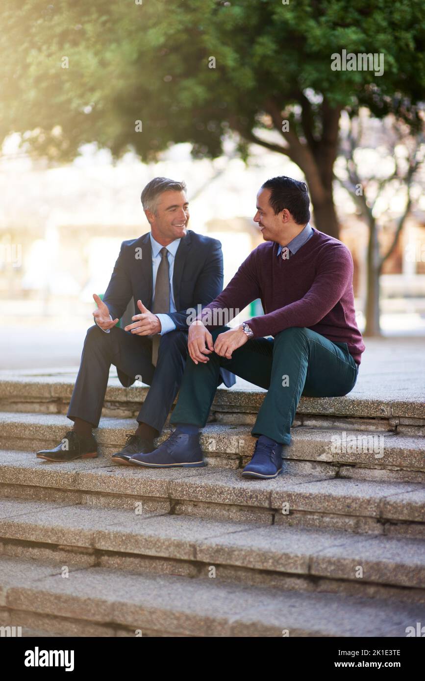 Catching up with a colleague. Full length shot of two coworkers sitting ...