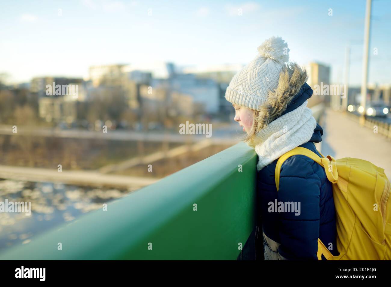 Cute young girl with a backpack heading to school on cold winter ...