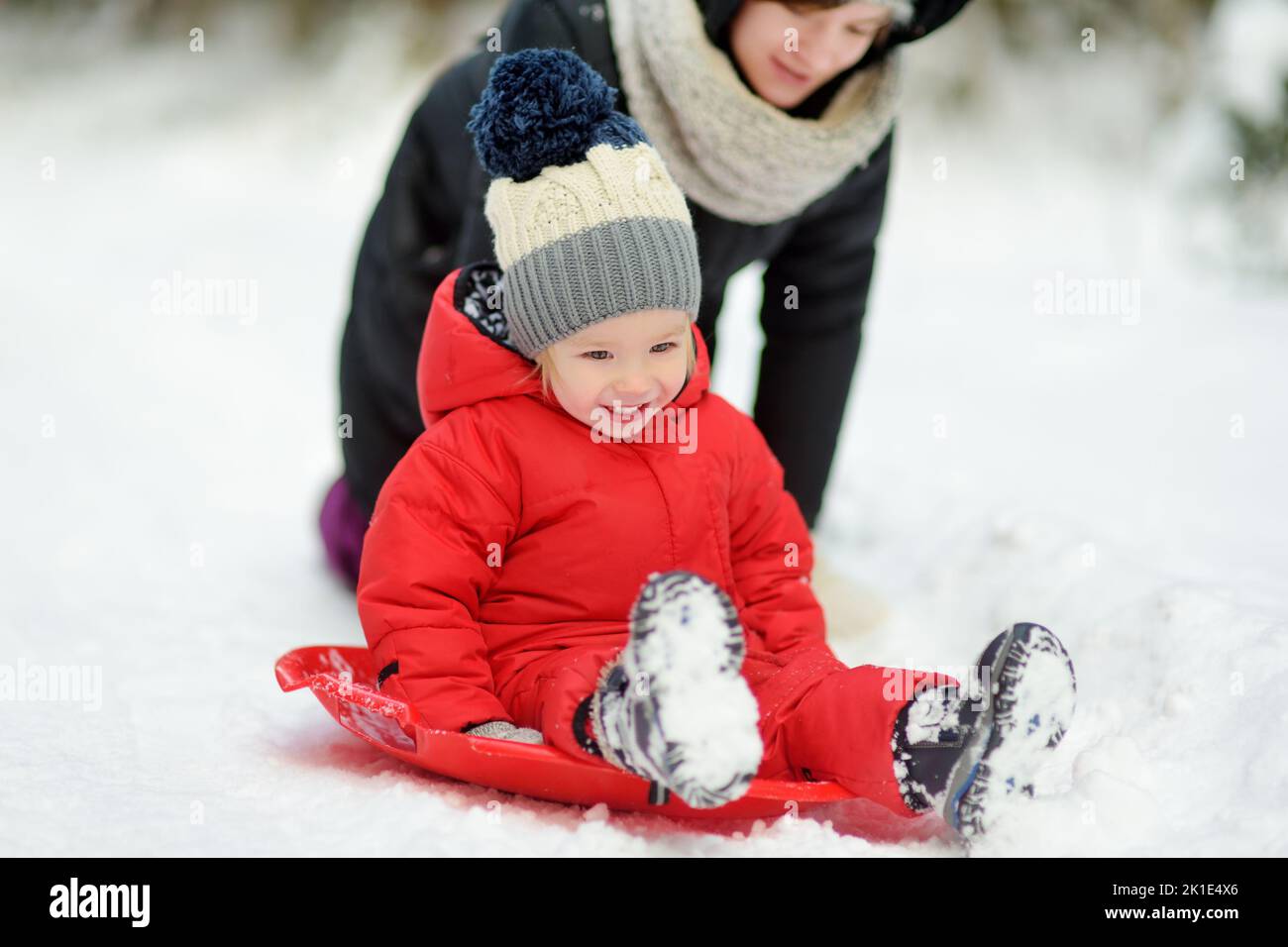 Cute young girl and her toddler brother having fun on a walk in snow ...