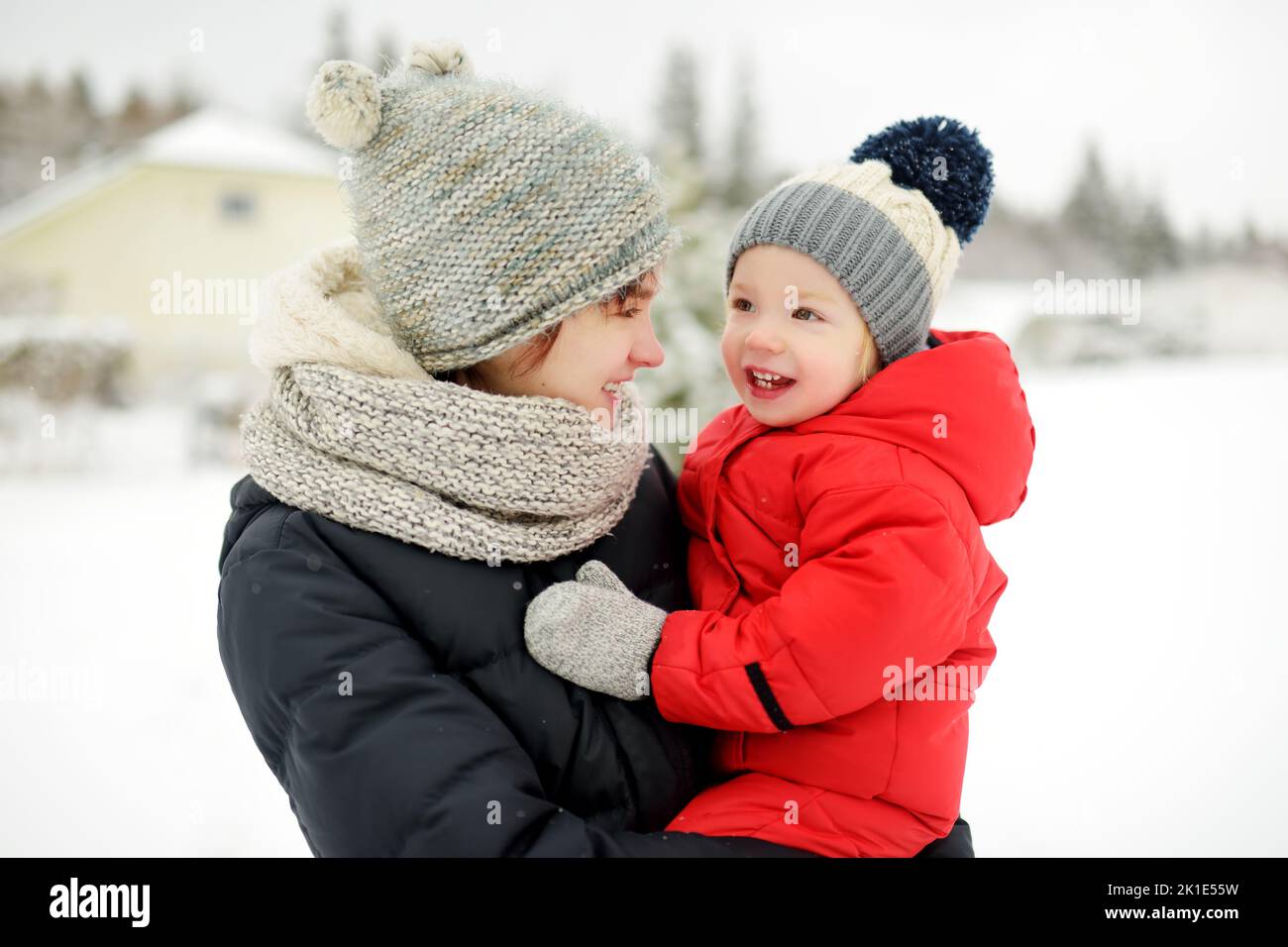 Cute young girl and her toddler brother having fun in snow covered park ...