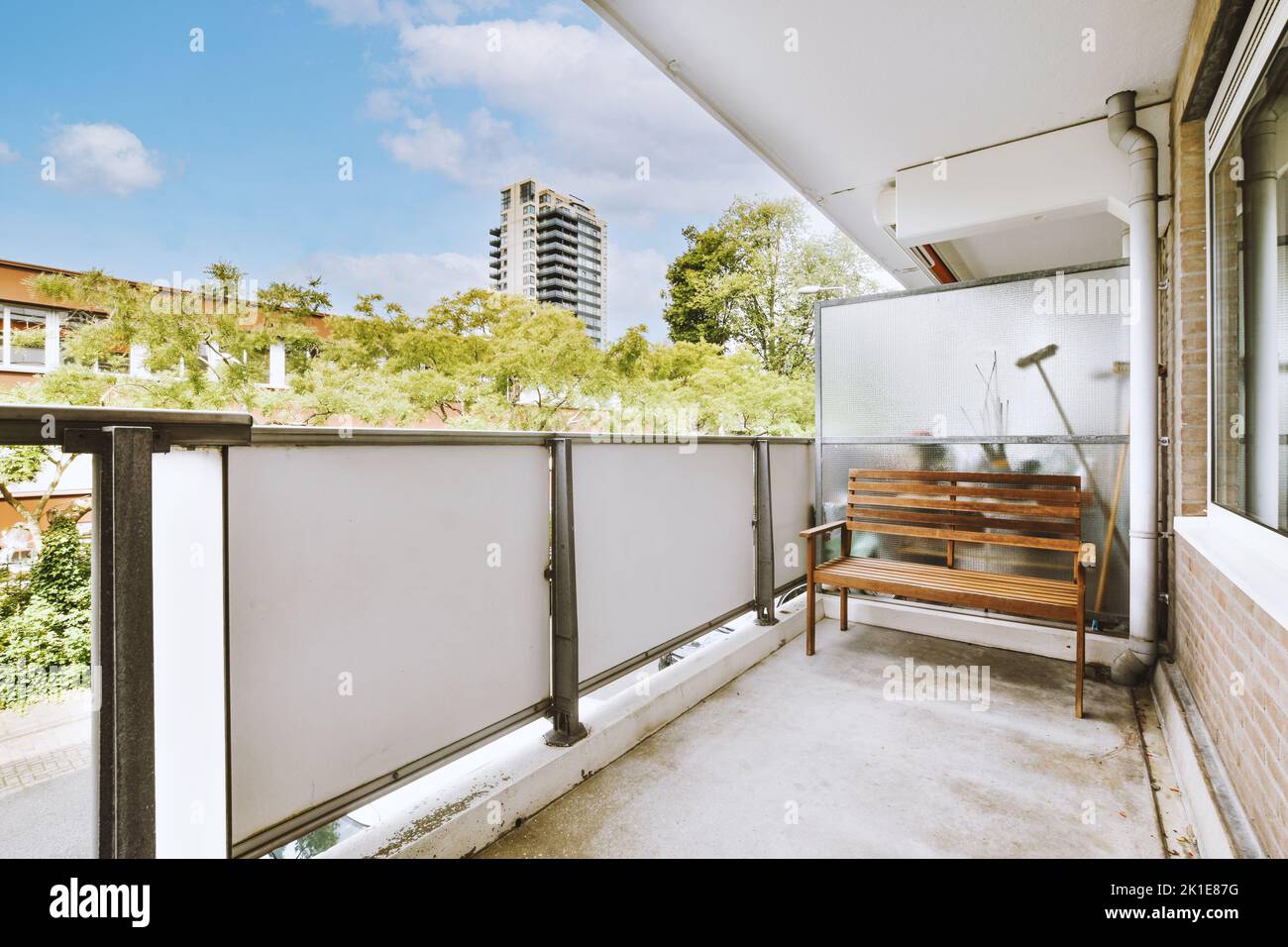 Narrow brick balcony with metal railings, wooden chair and door Stock ...
