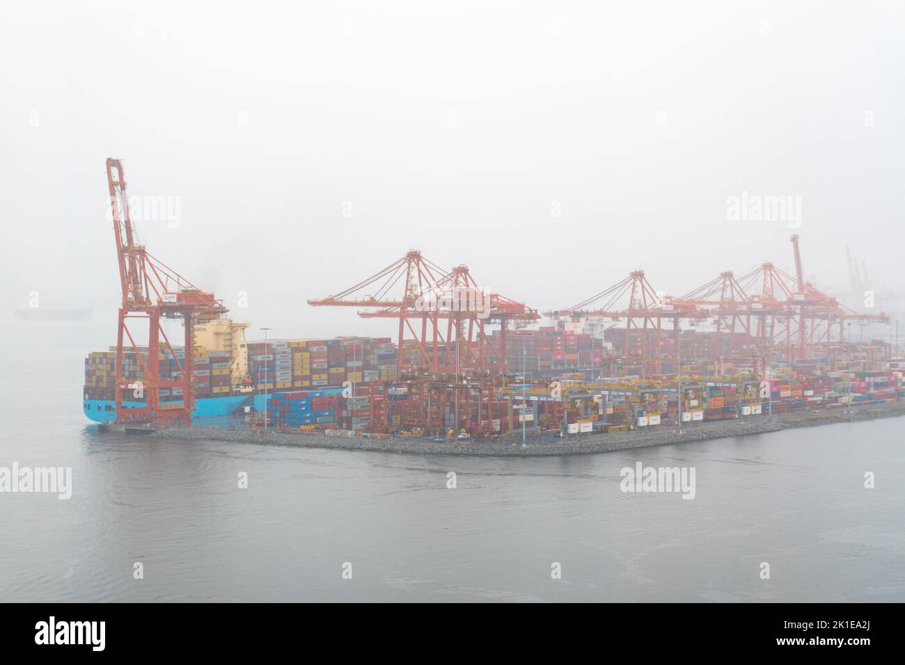 Busy shipping container terminal in the fog during a rainy day in ...