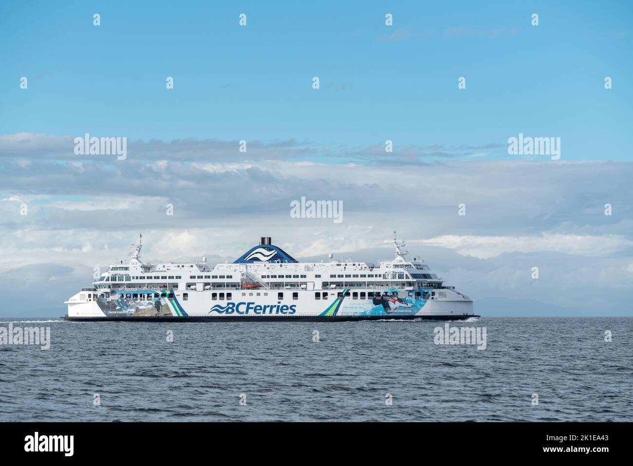 A large ferry sails through the Strait of Georgia near the border of ...