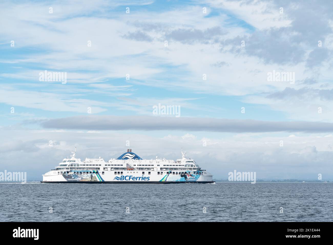 A large ferry sails through the Strait of Georgia near the border of ...