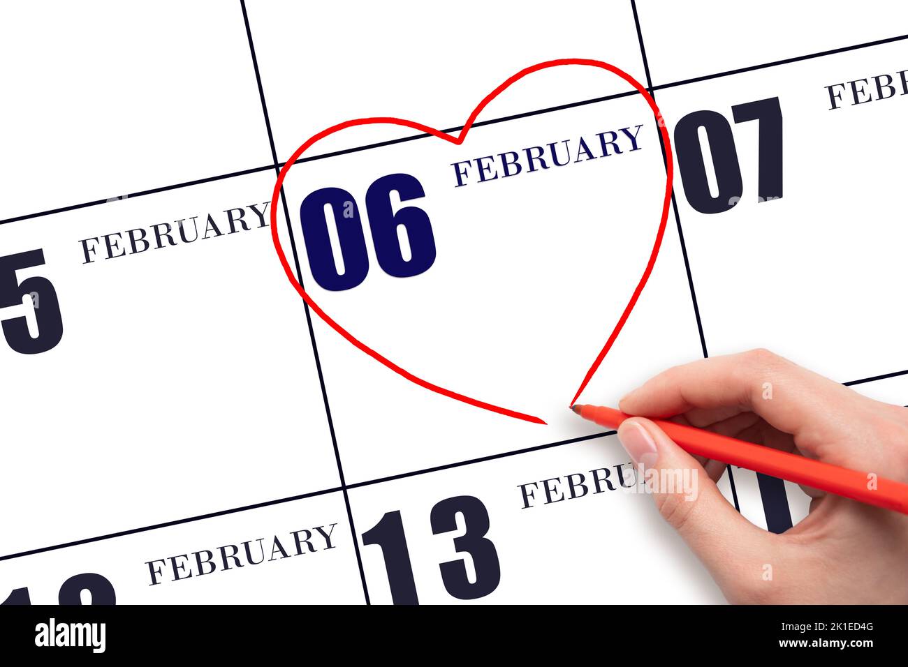 6th day of February. A woman's hand drawing a red heart shape on the ...