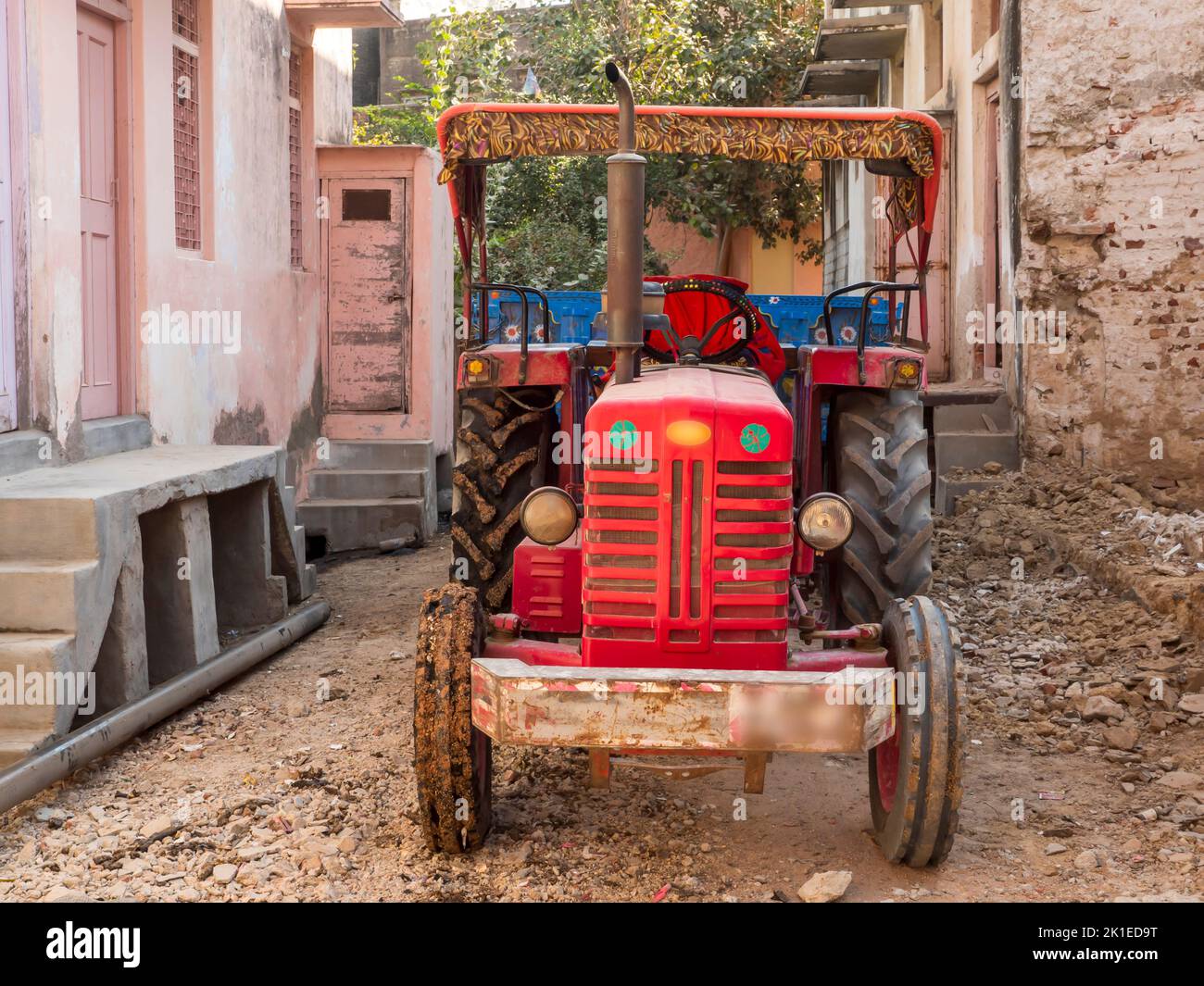 Tractor use in construction, park in street of Indian rural village ...